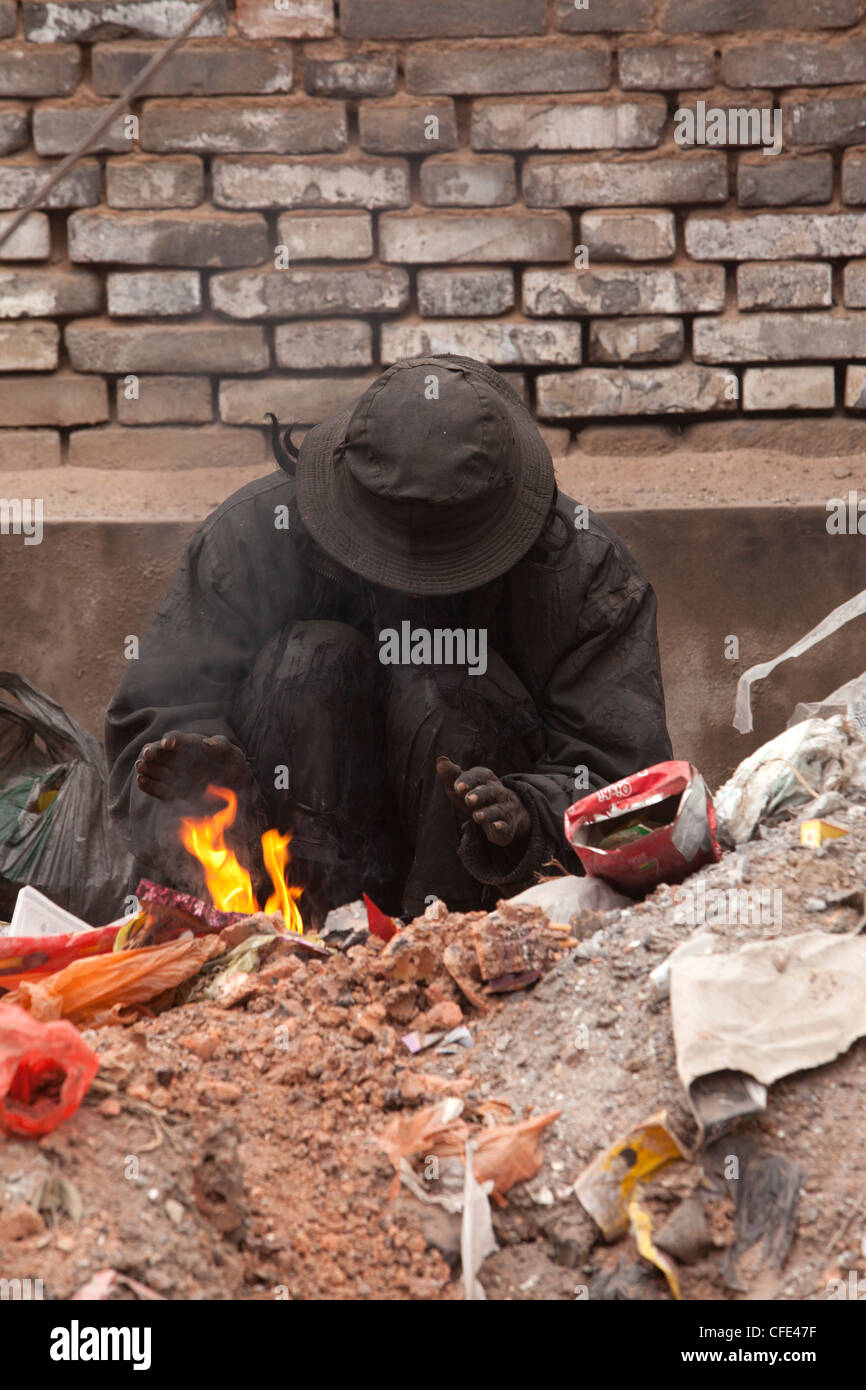 Homeless keeping warm in fire, China Stock Photo - Alamy