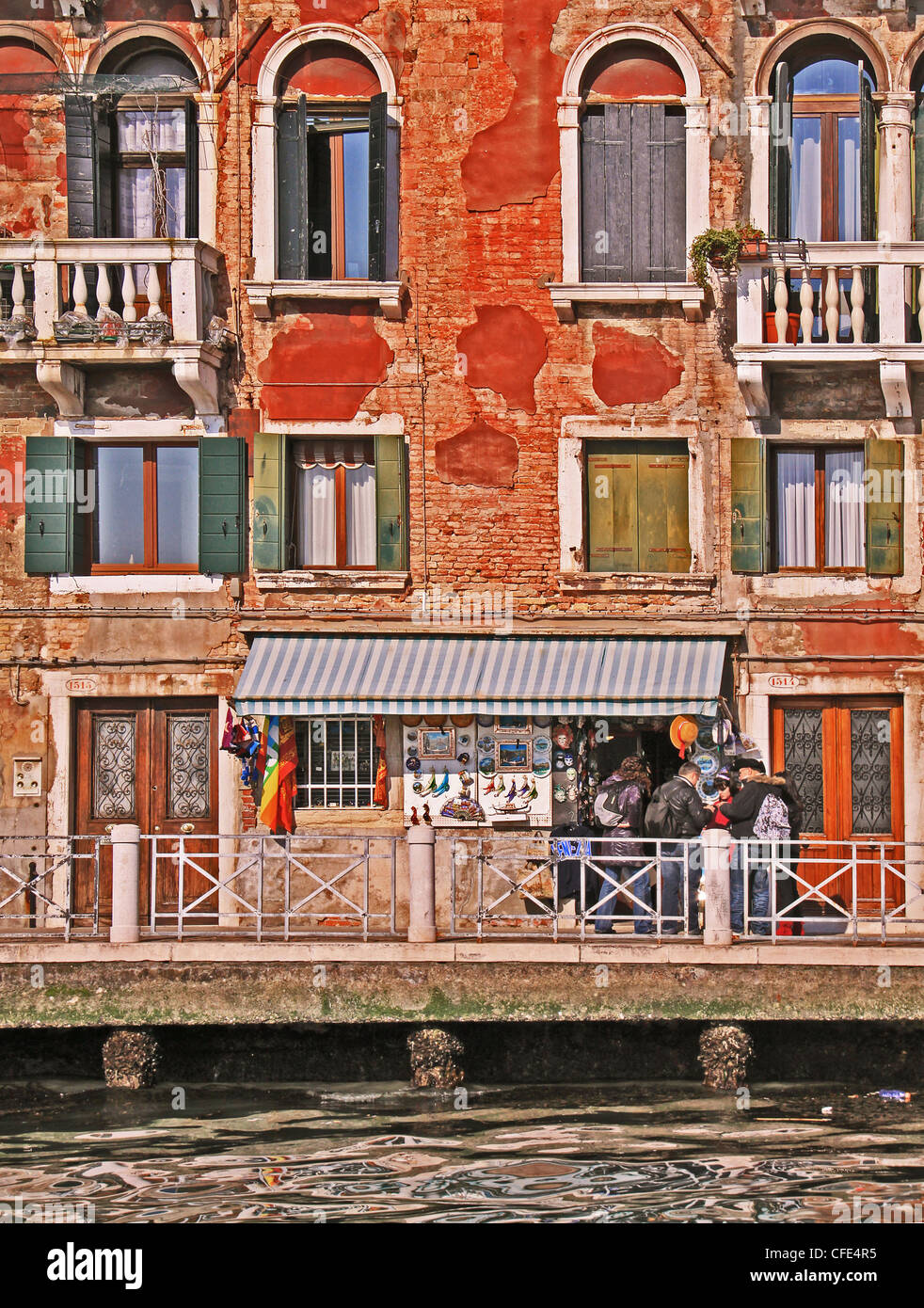 Venice, ancient building facing the water and tourists in front of a ...
