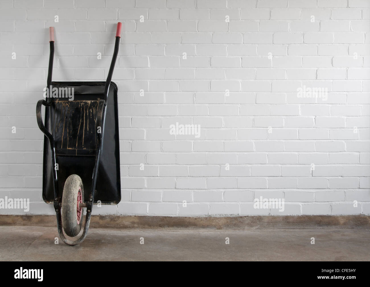 Old wheelbarrow leant against brick wall Stock Photo - Alamy