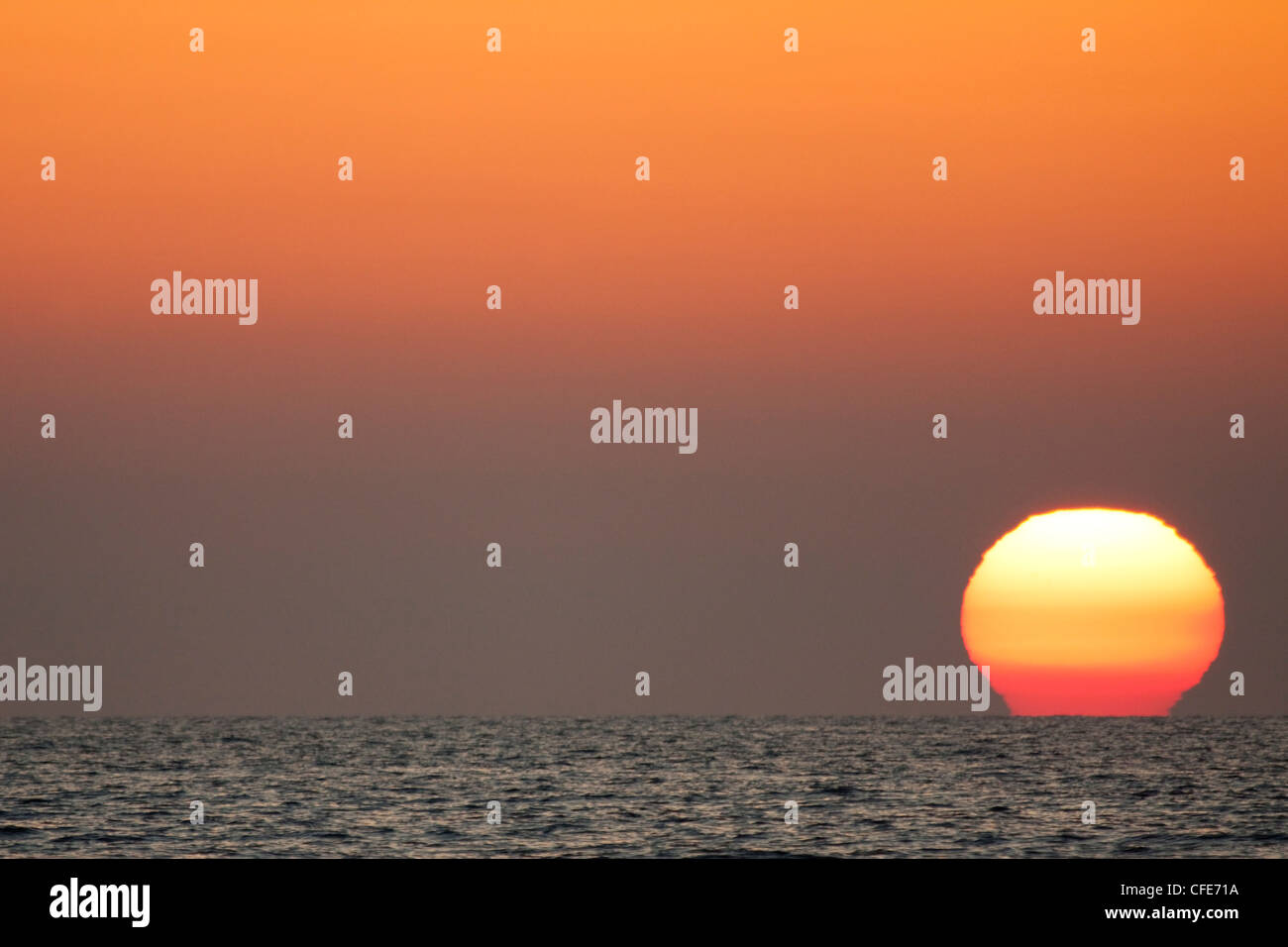 The sun setting over the sea Stock Photo - Alamy
