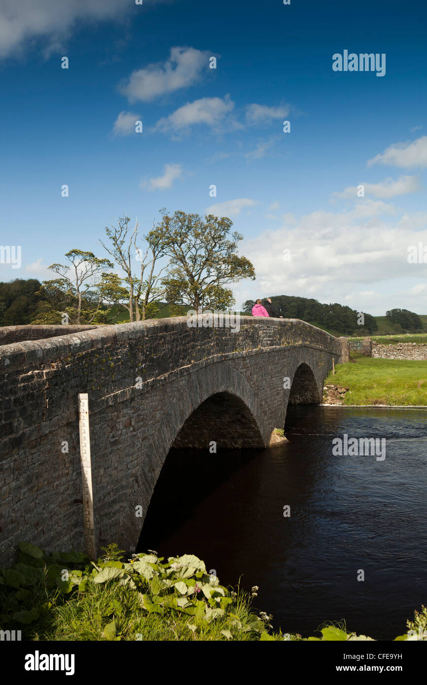 UK, England, Yorkshire, Wensleydale, Hawes, walkers crossing bridge ...