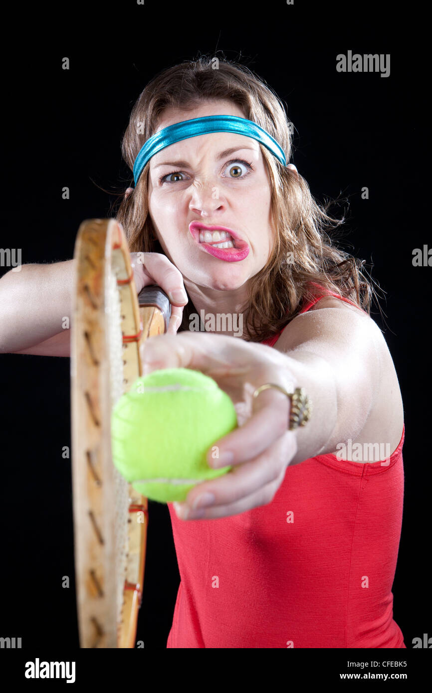 Goofy retro athlete holds tennis racket and ball while making a silly ...