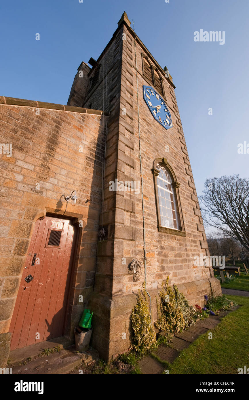 External doorway entrance (wooden door closed) at base of church belfry ...