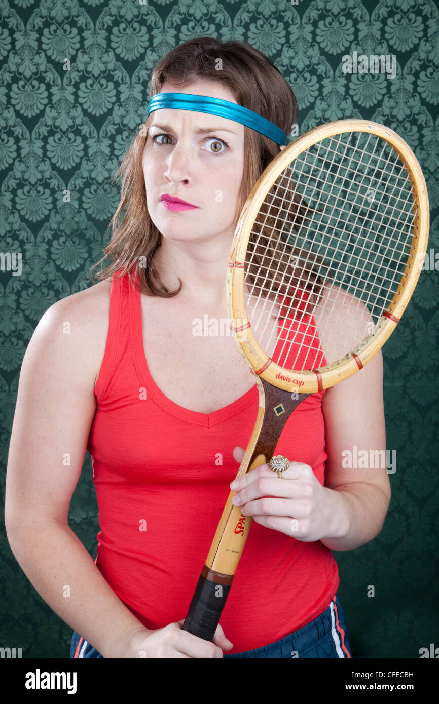 Goofy woman athlete holding a tennis racket making a funny face Stock ...