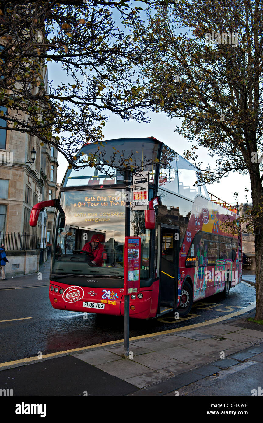 A double decker bus waits in evening sunshine at a bus stop in Bath, UK ...