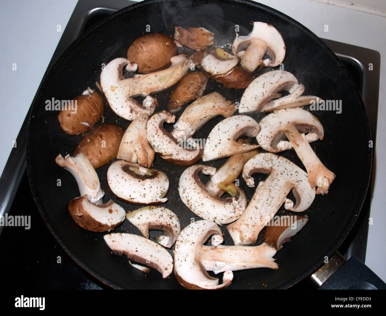 Champignons in a frying pan Stock Photo - Alamy