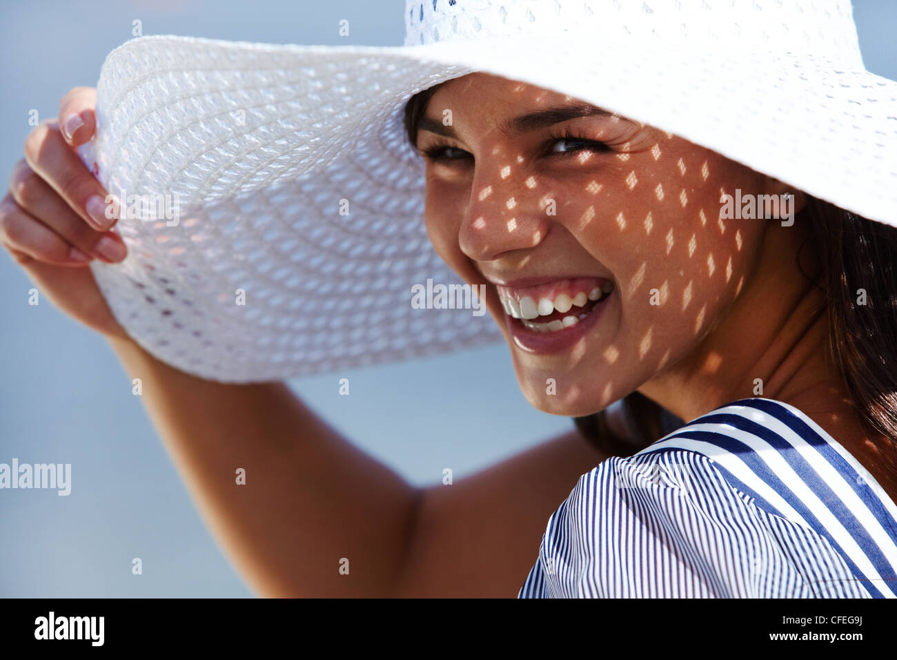Cheerful girl holding brim hat hi-res stock photography and images - Alamy