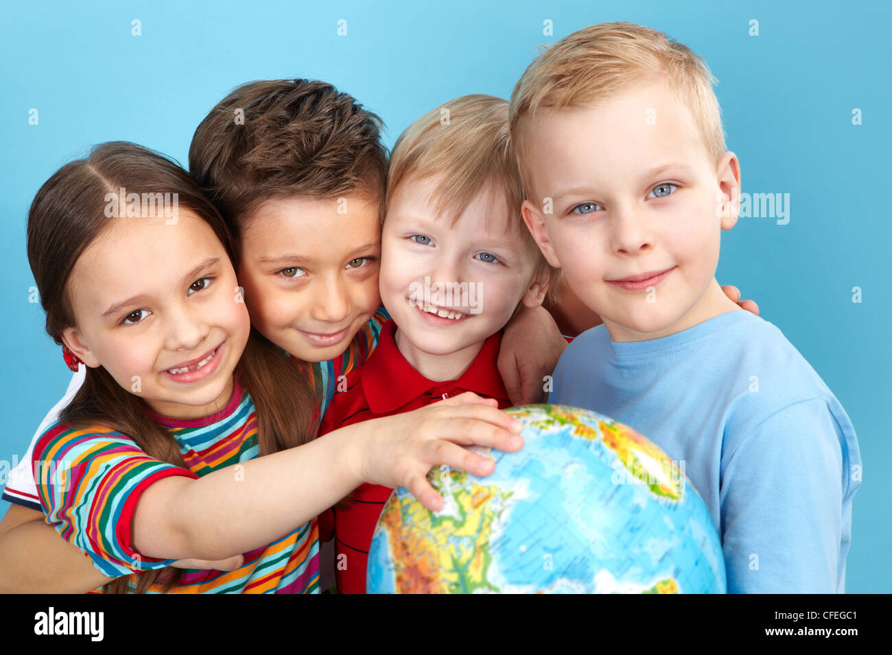 School children holding a globe looking at camera positively Stock ...