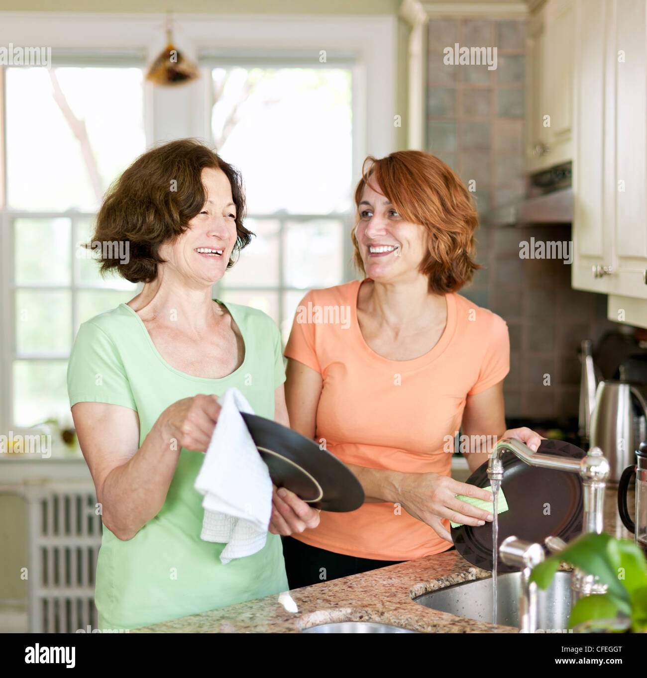Mother and daughter doing dishes in kitchen at home Stock Photo - Alamy