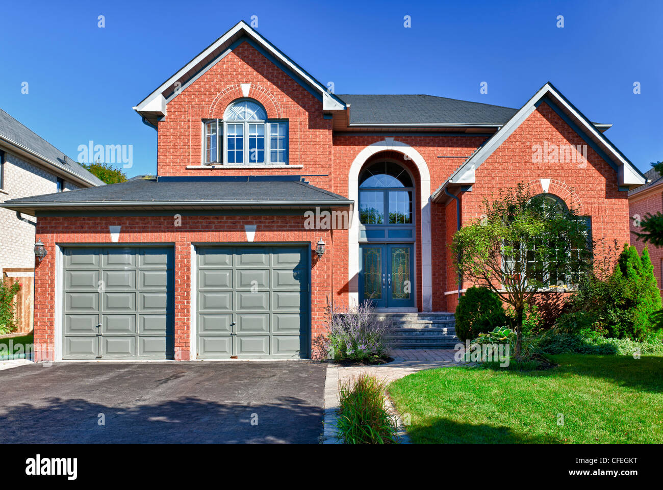 Brick house in suburbs with two car garage Stock Photo - Alamy