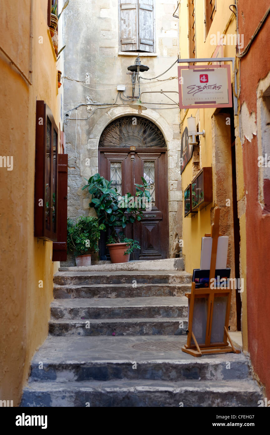 A stoned tiled winding alleyway lined with colourful pot plants ...