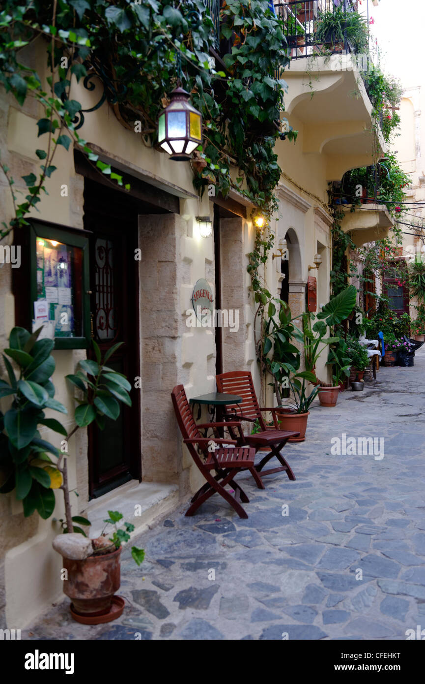 A stoned tiled winding alleyway lined with colourful pot plants ...