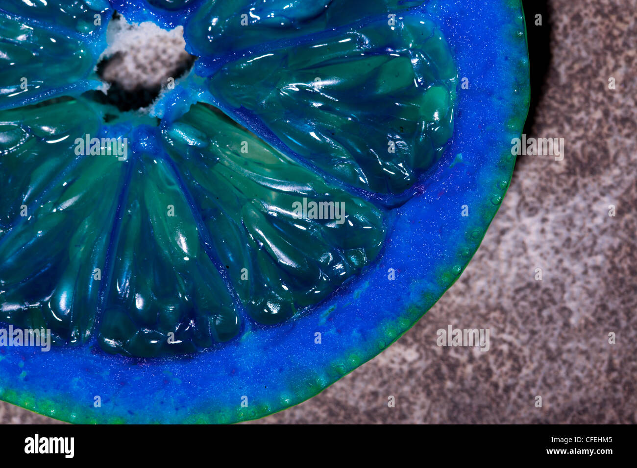 Macro shot of a slice of blue dyed lemon on a piece of grey tile Stock ...