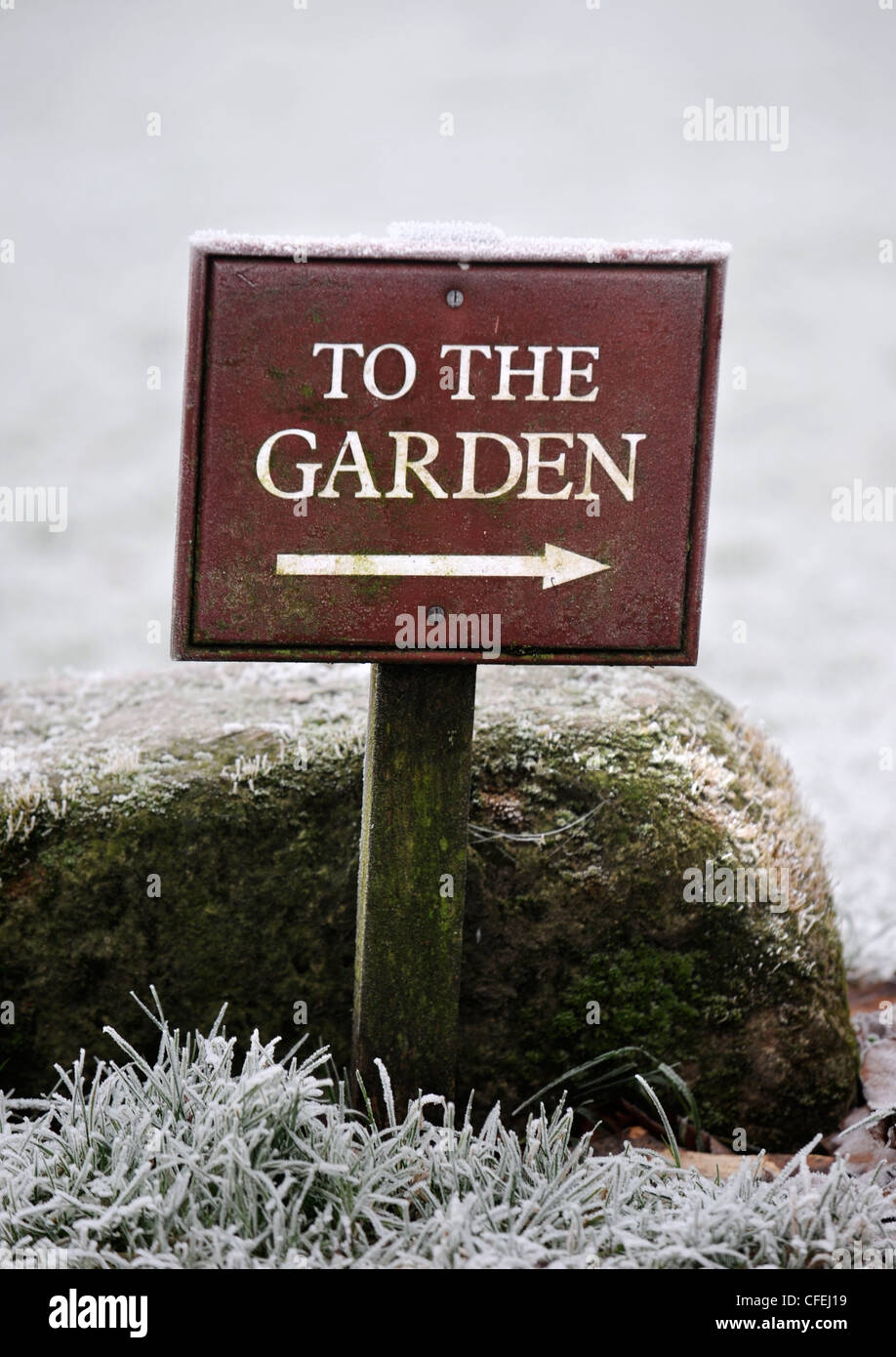 A sign pointing the way to an open garden on a frosty winter day in ...