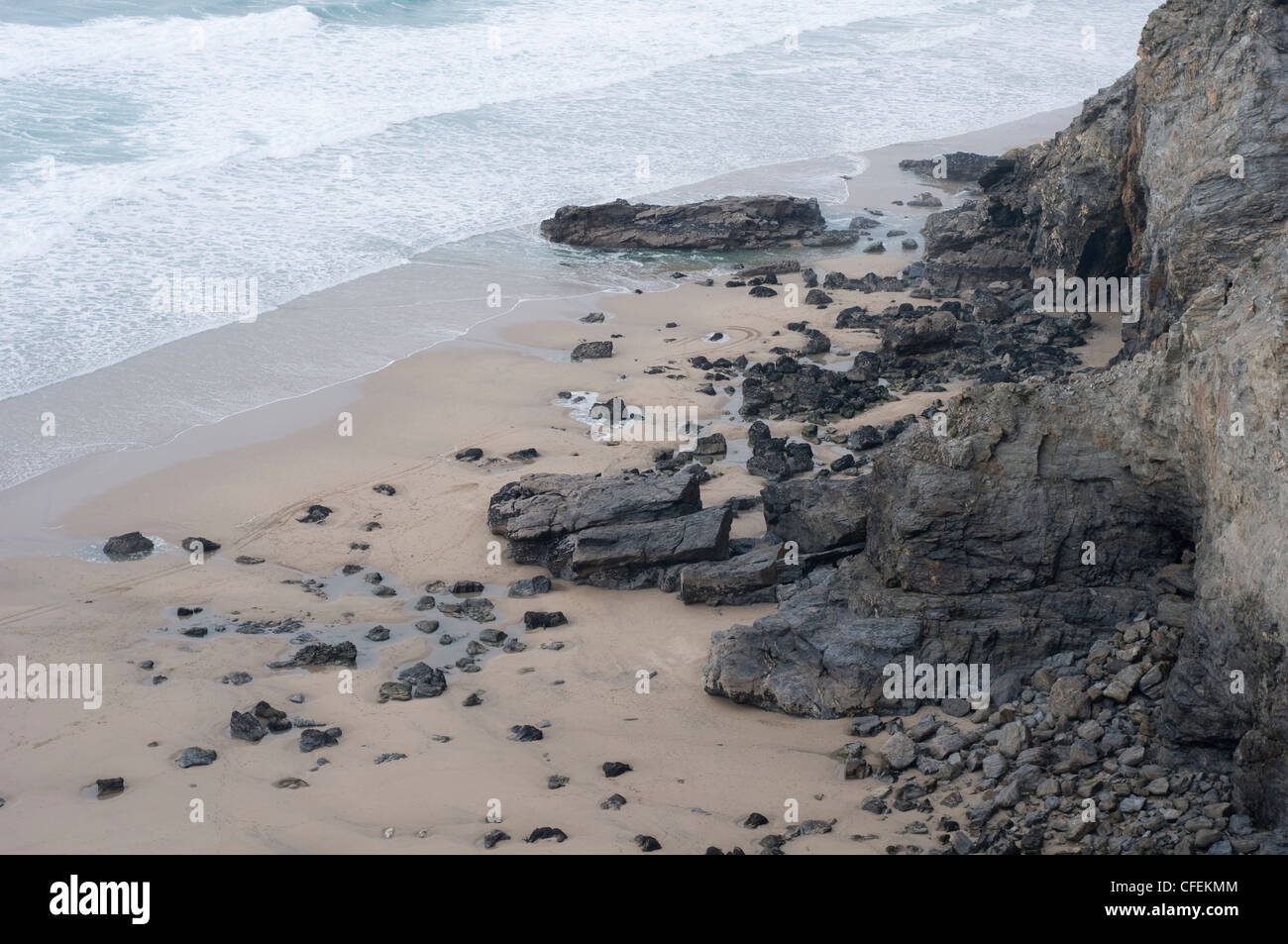 Beach view from cliffs, blue waves, sandy beach with scattered rocks ...