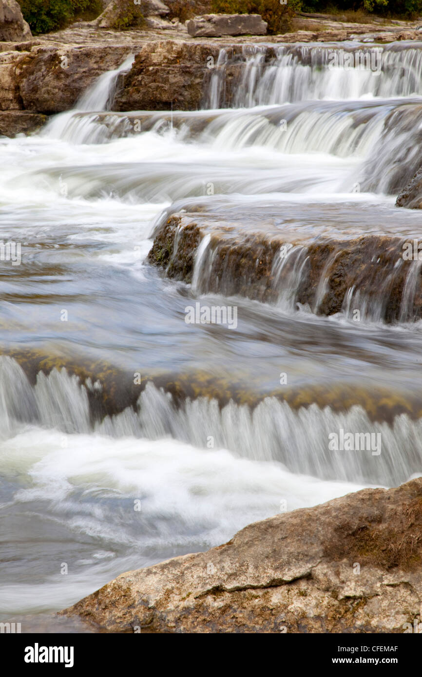 Series of Rapids/Waterfalls. Soft water and rocks fill vertical frame ...