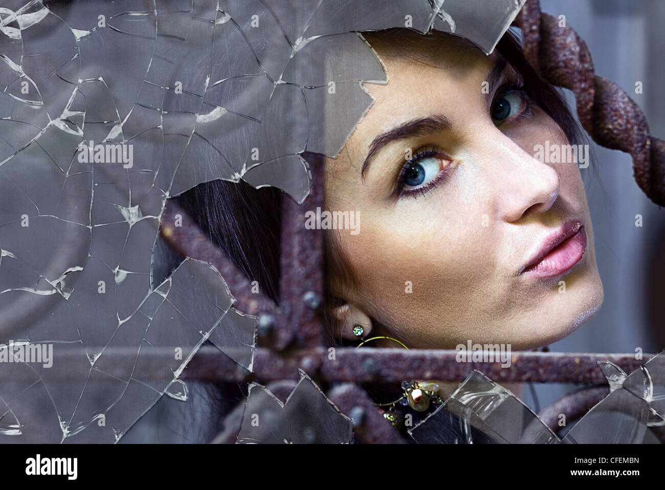 The sad woman behind a broken window Stock Photo - Alamy