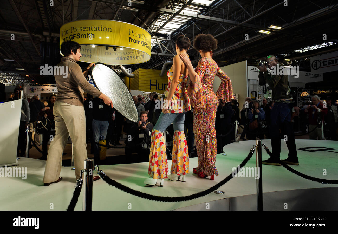 Photographer taking photographs of female models on a stand at the ...