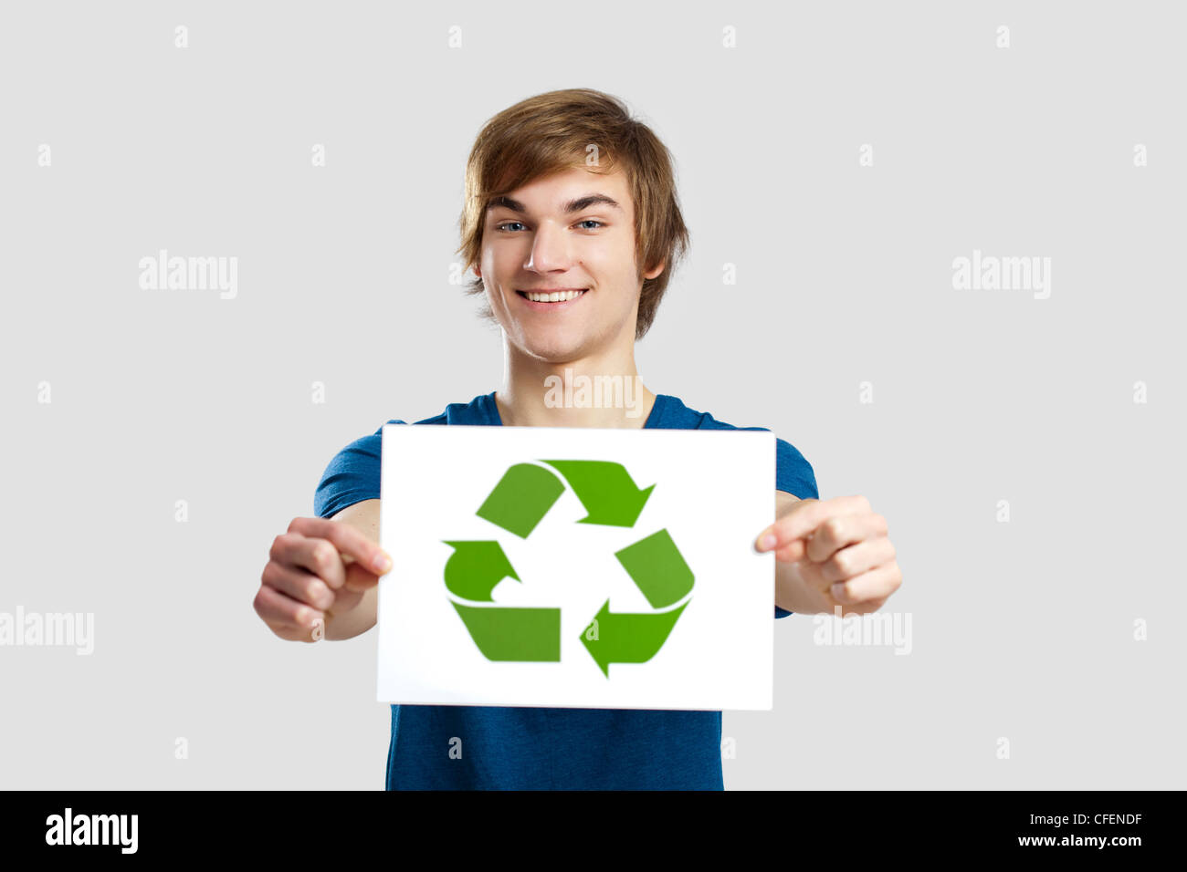 Casual young man holding a recycling sign to promote a green and better ...