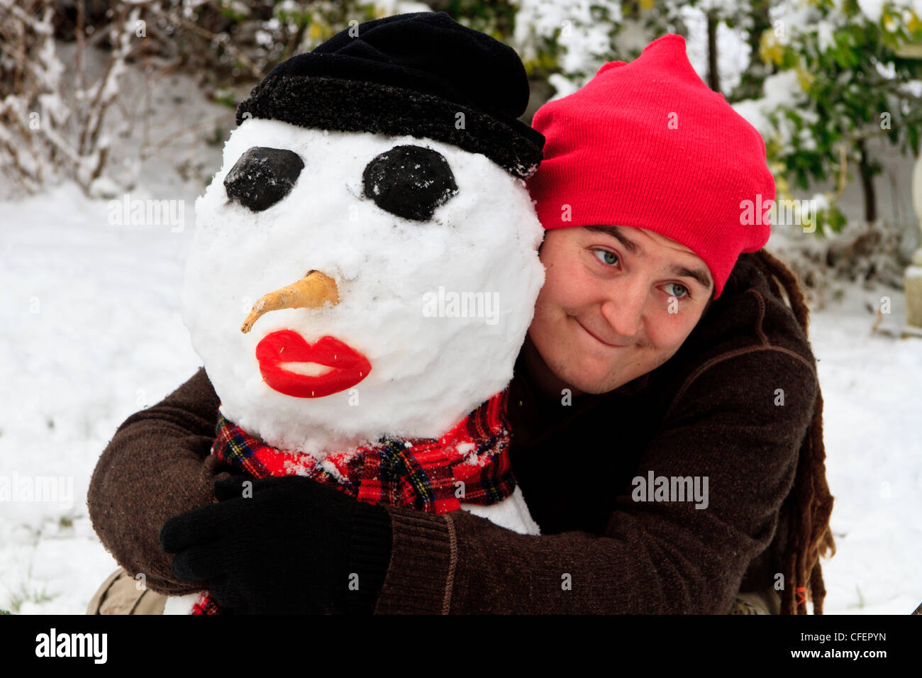 Young man hugging a snowman Stock Photo - Alamy