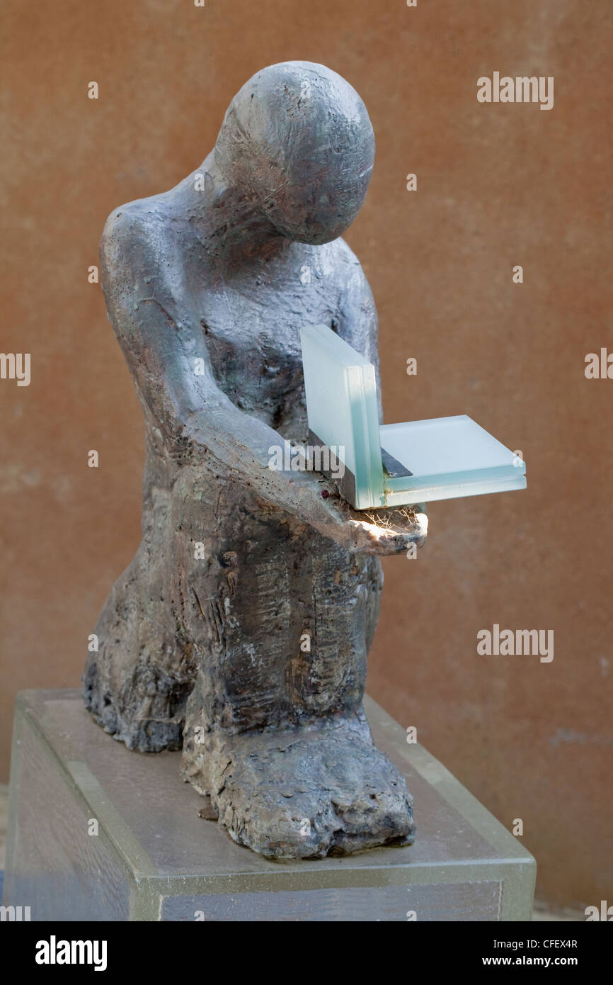 Metal and glass sculpture of person reading a book at Cornerstone ...