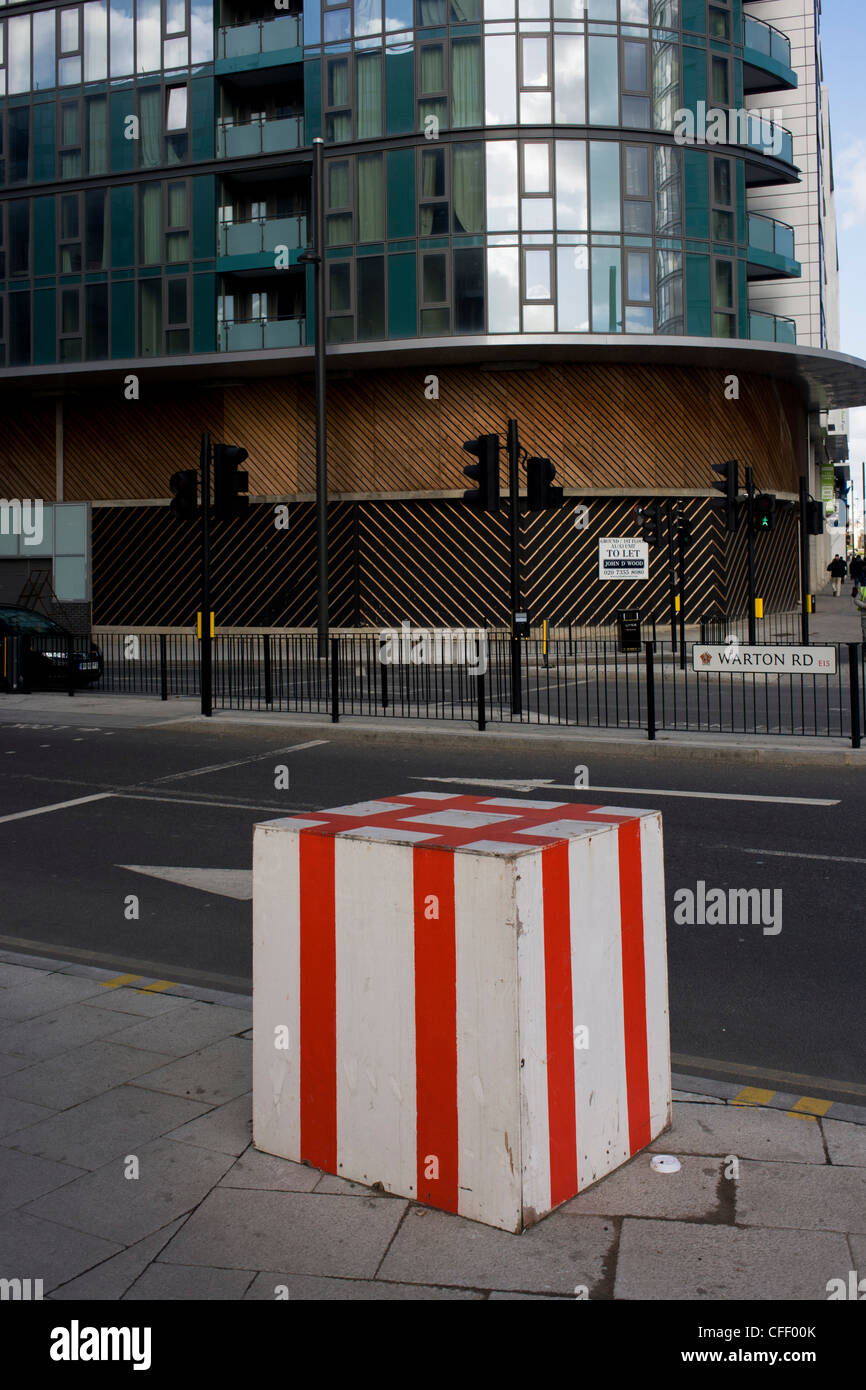 Red and white striped cuboid sits on the pavement near recently ...