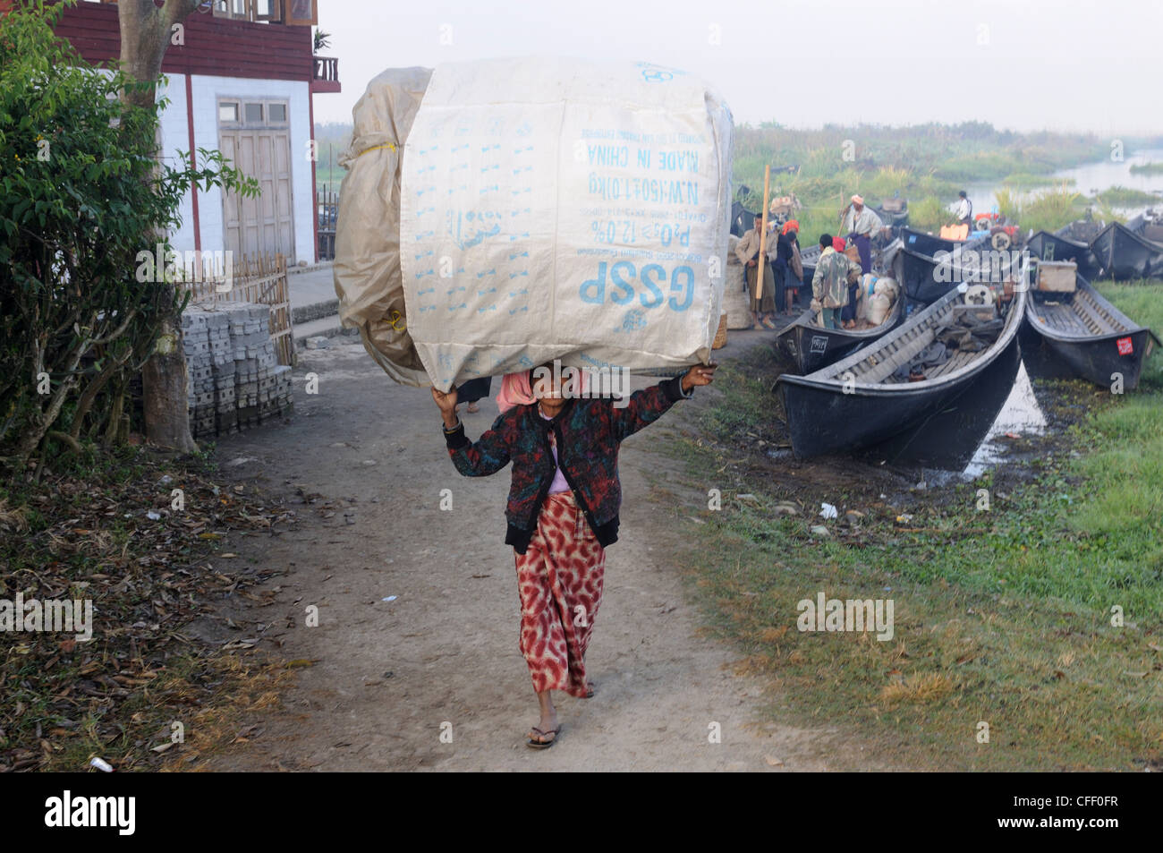 Woman carrying a giant package on her head at a local market on the ...