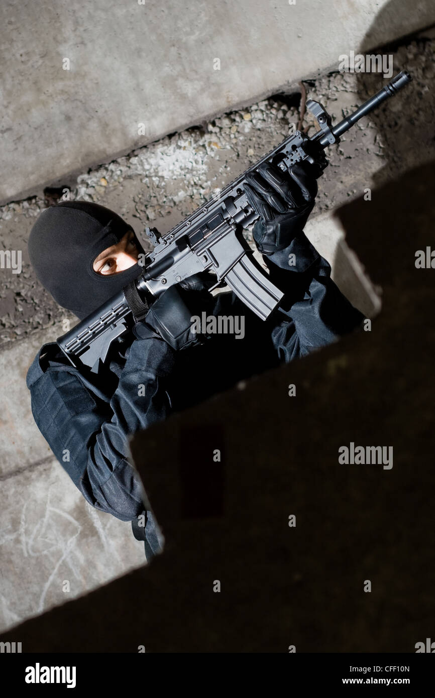 Armed and dangerous man in black uniform aiming the target Stock Photo ...