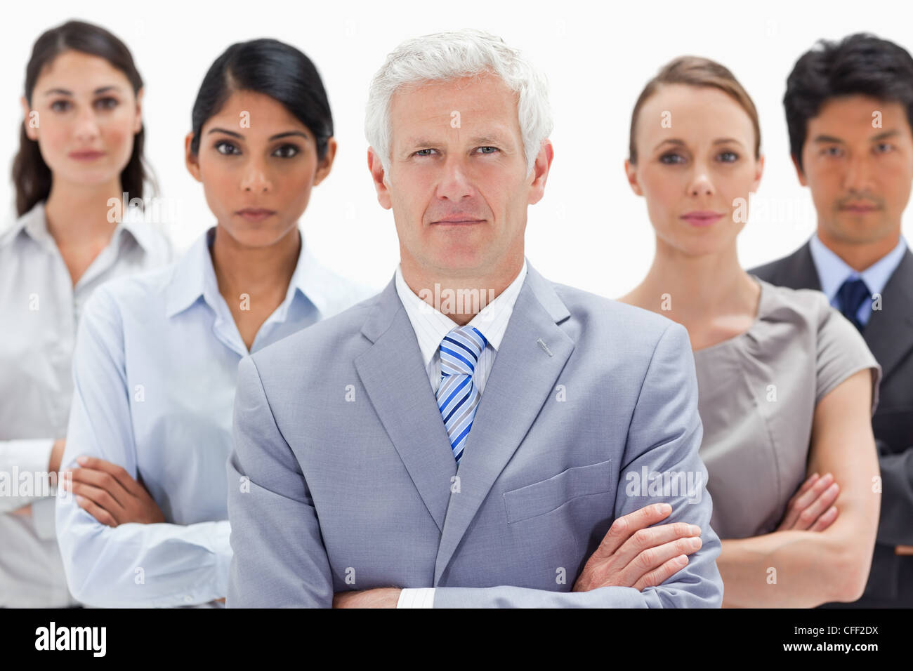 Close-up of a serious multicultural business team behind their boss ...
