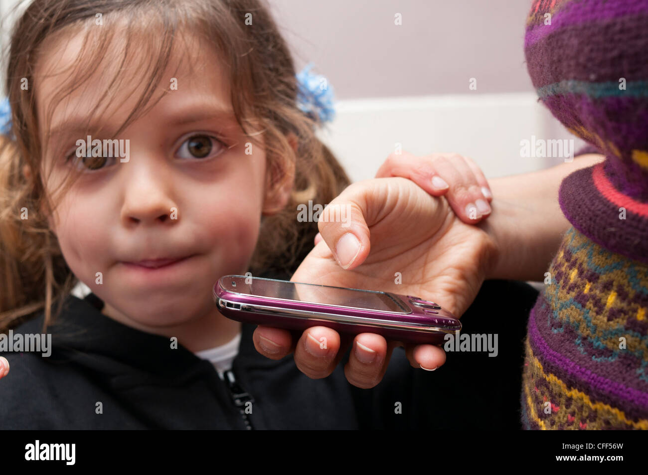 Parent on smartphone ignoring child. Young child wanting adult's ...