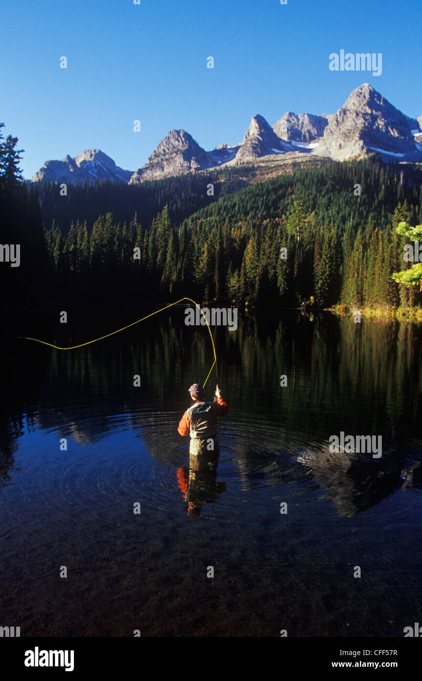 Young man fly-fishing on Island Lake in the Lizard Range near Fernie ...