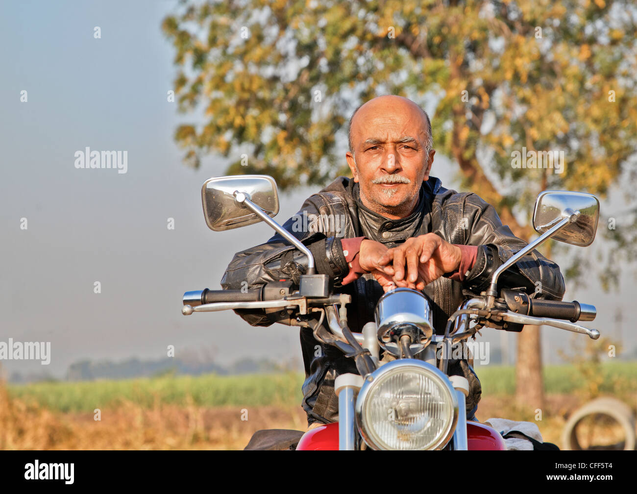 Gujarat, India, Senior citizen Indian biker on a red homeland cruiser ...
