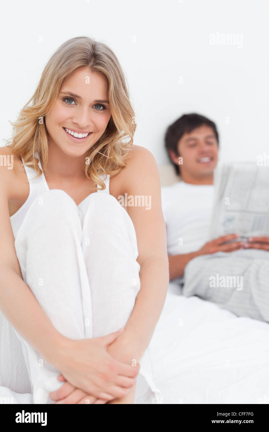 Close up, Woman sitting at the bottom of the bed, with the man at the ...