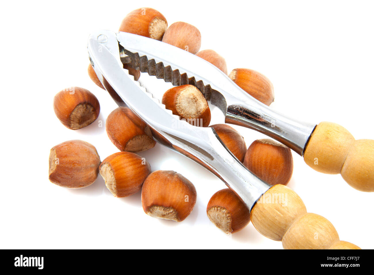 Hazelnuts with nut cracker isolated over white Stock Photo - Alamy