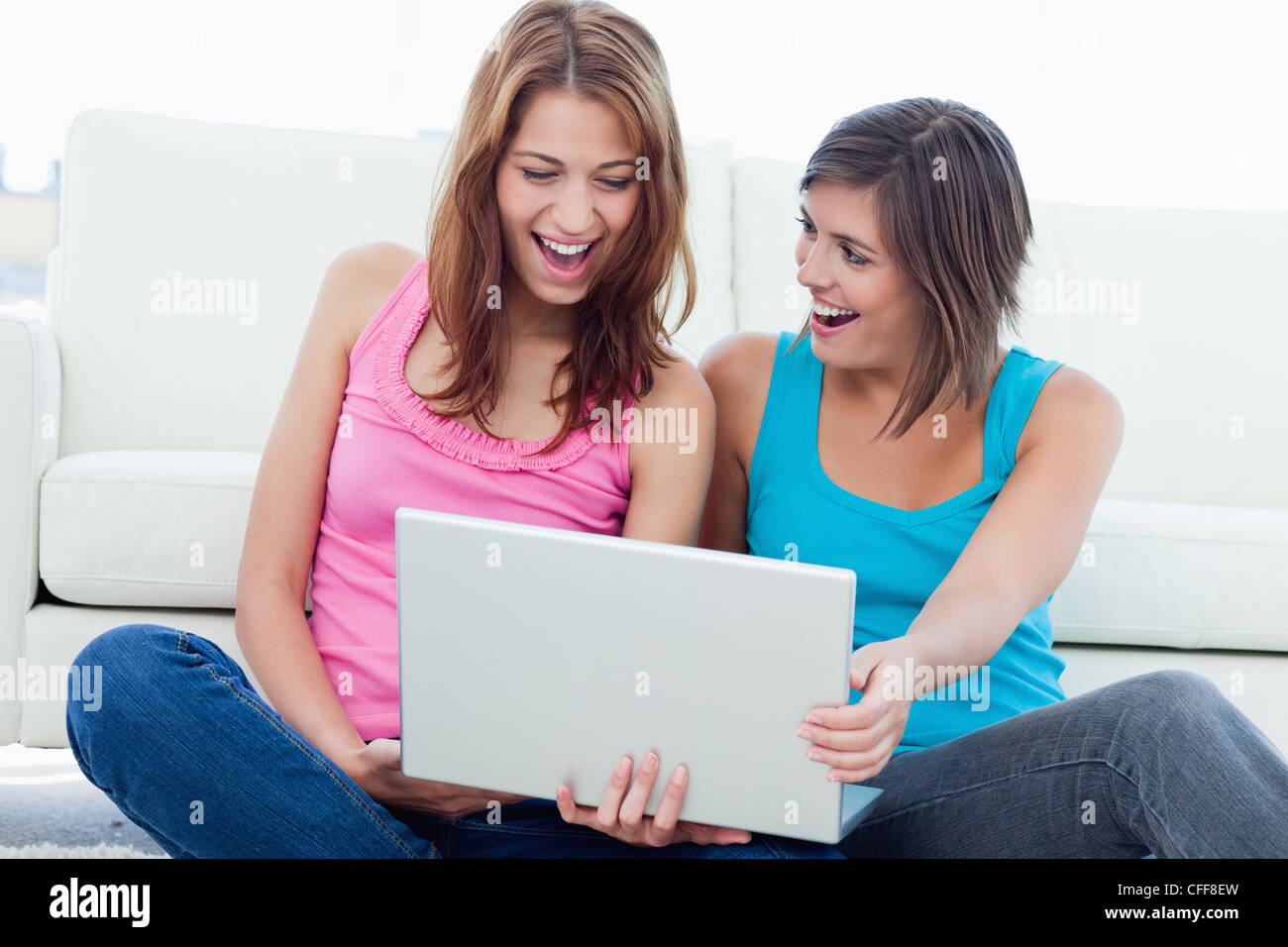 Young woman proudly showing the laptop screen to her friend Stock Photo ...