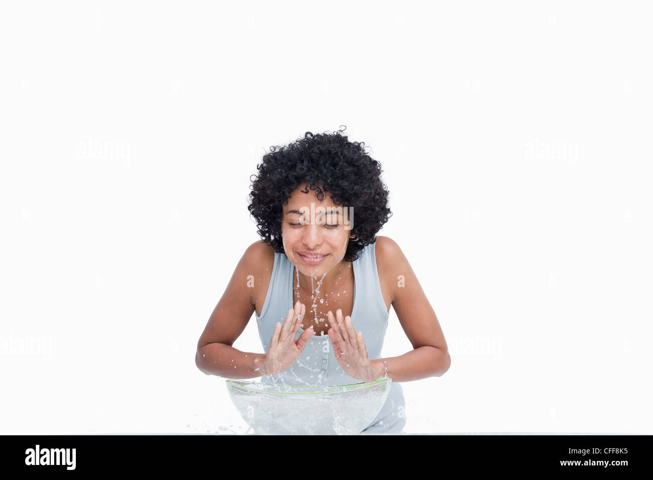 Calm young woman rinsing her face against a white background Stock ...