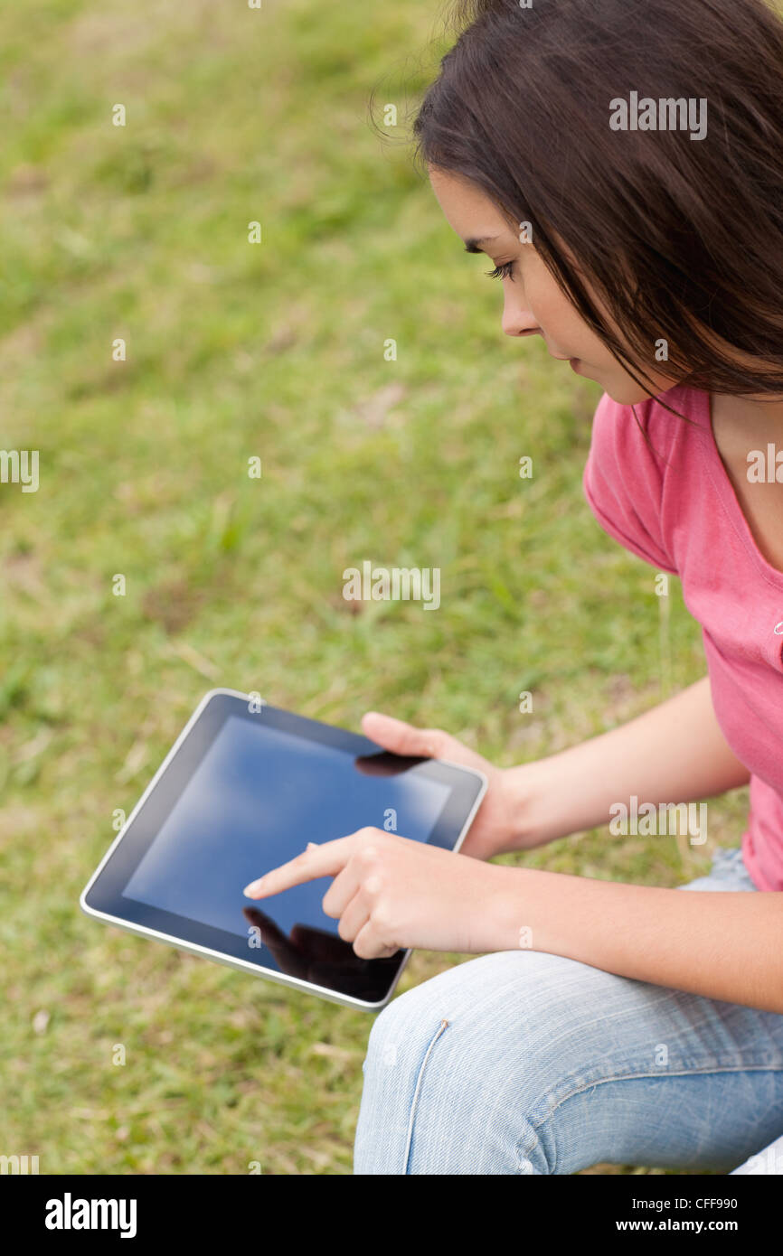 Young serious woman using her tablet pc in a park Stock Photo - Alamy