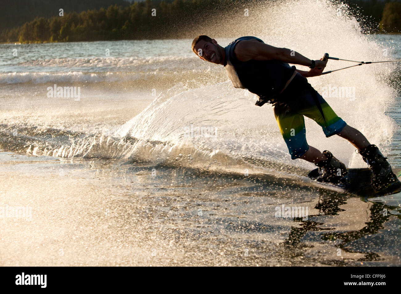 A professional wakeboarder smiles while he carves and slashes on Lake ...