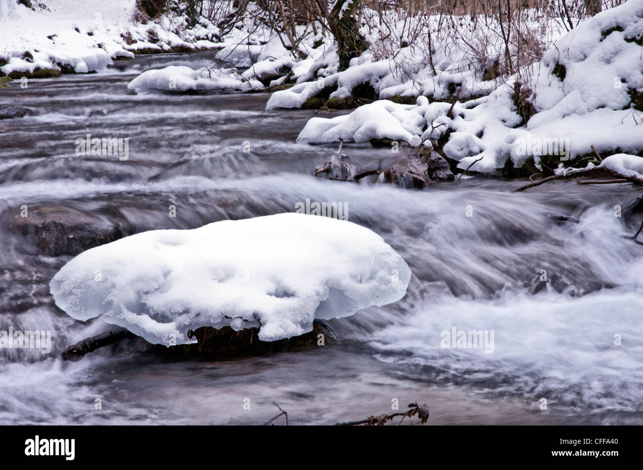 Small mountain watercourse in winter with ice floes and moss-covered ...
