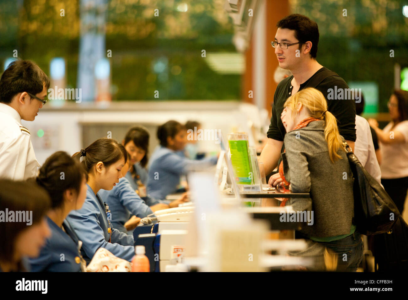 Passengers check-in for their Singapore Airlines Ltd. flight at Changi ...