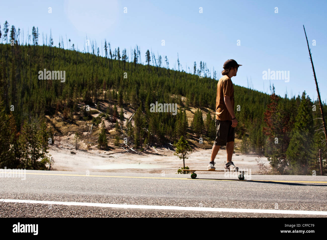 A young man longboarding in a national park in Montana Stock Photo - Alamy