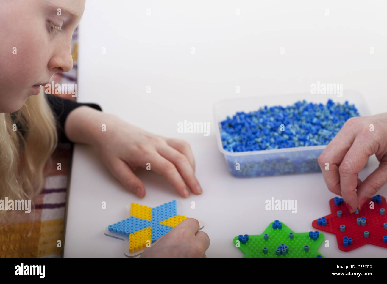 Mother and child playing with Hama beads Stock Photo - Alamy