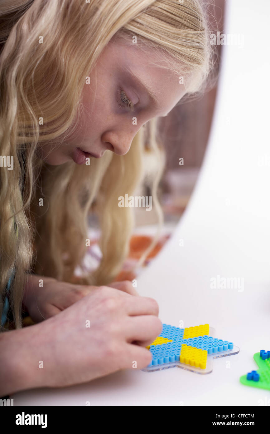 Little blond girl playing with Hama beads Stock Photo - Alamy