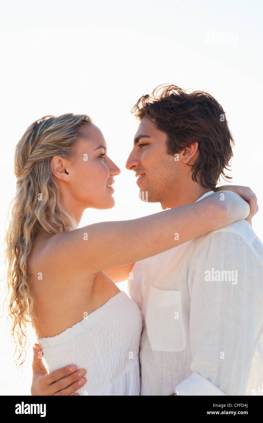 Side view of hugging couple against the sunset Stock Photo - Alamy