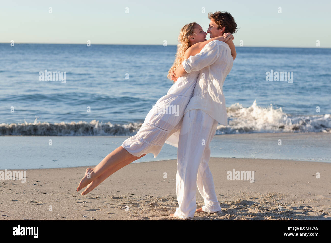 Couple spinning at the beach during sunset Stock Photo - Alamy