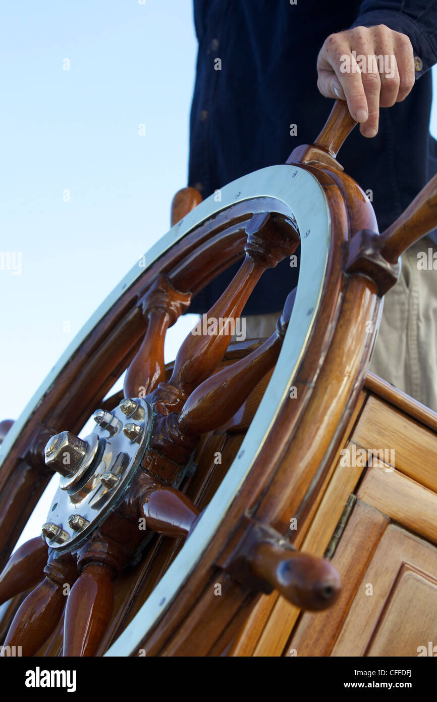 The captain keeps his hand on ship's wheel on board the sailing yacht ...