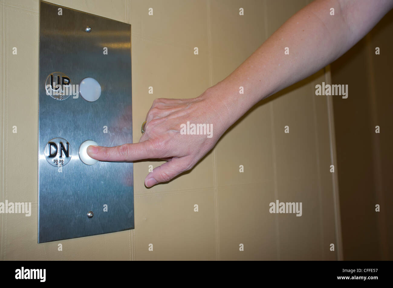 Woman's Finger Pressing Elevator Down Button Stock Photo - Alamy