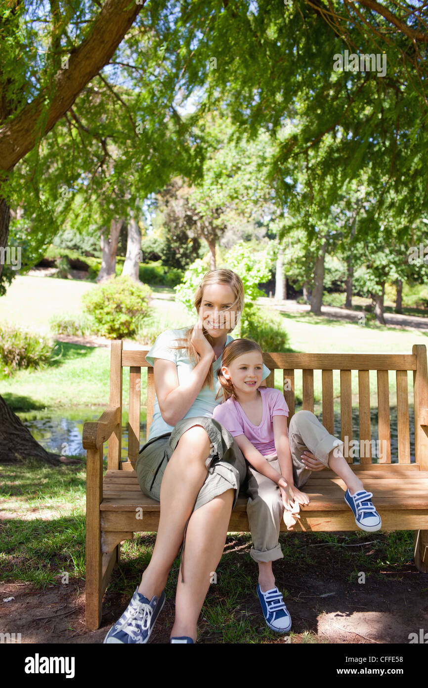 Mother and daughter sit on a bench together Stock Photo - Alamy