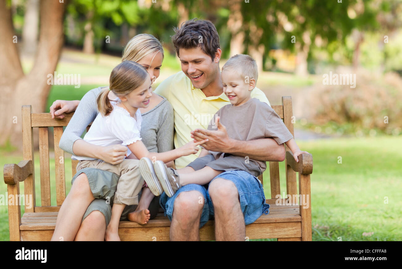A happy family playing while they sit on the bench Stock Photo - Alamy
