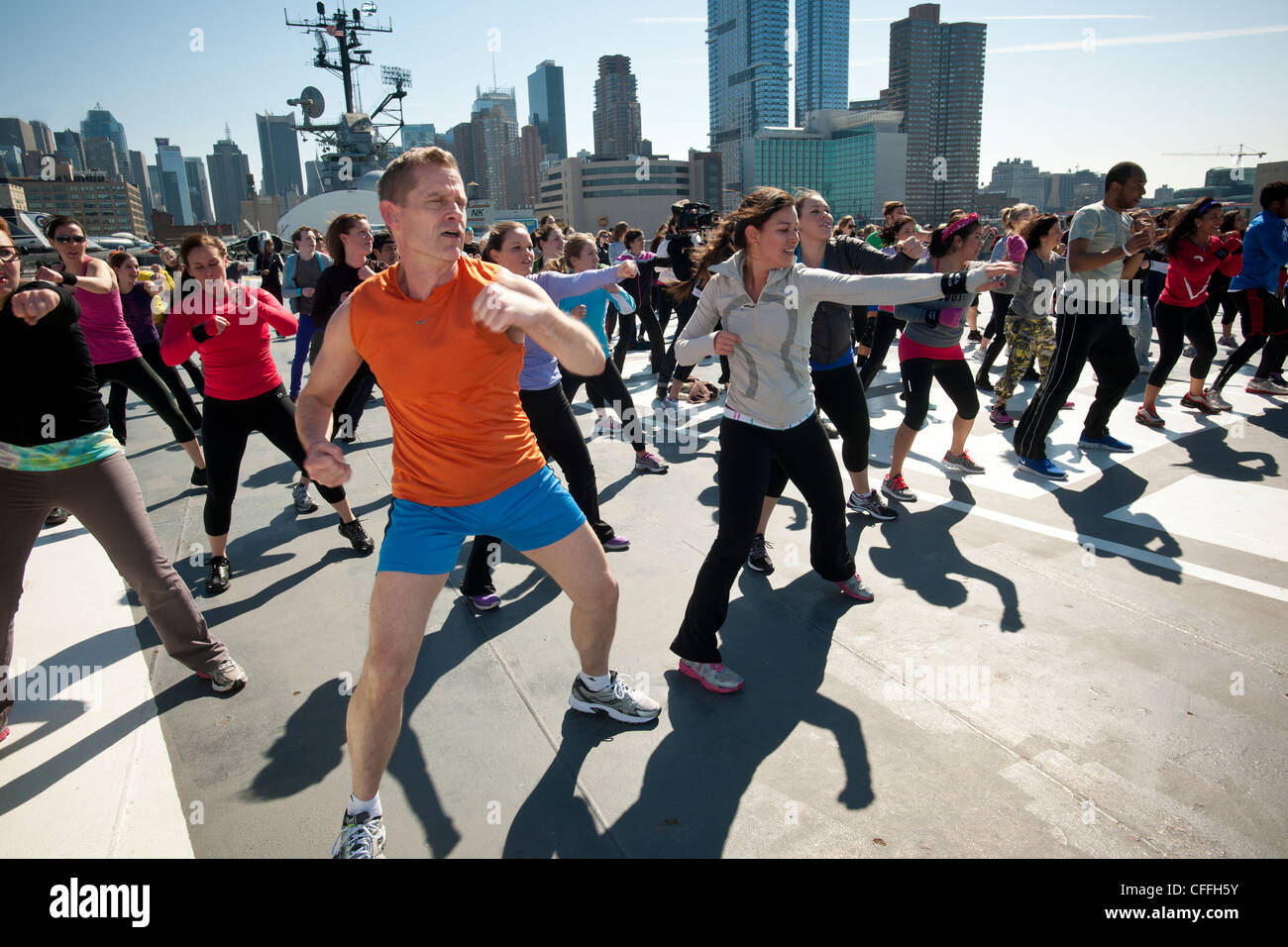 Exercisers participate in an exercise class on the flight deck of the ...